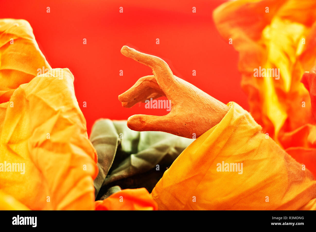 One beautiful wooden hand making a token gesture , a vibrant yellow and ...