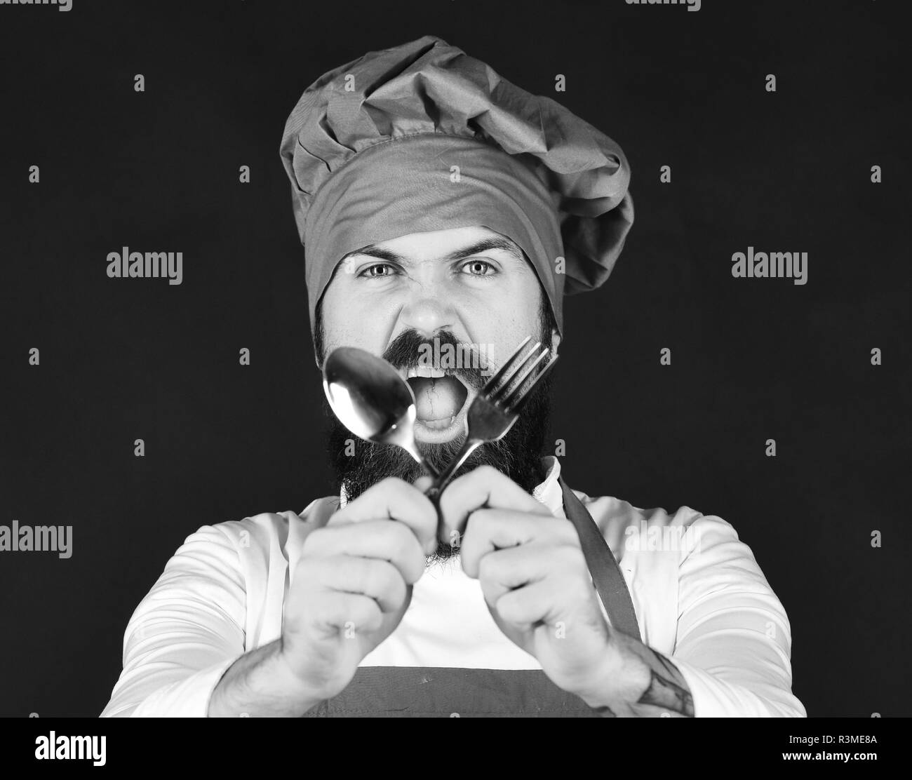 Kitchen utensils concept. Man with beard holds kitchenware on black ...