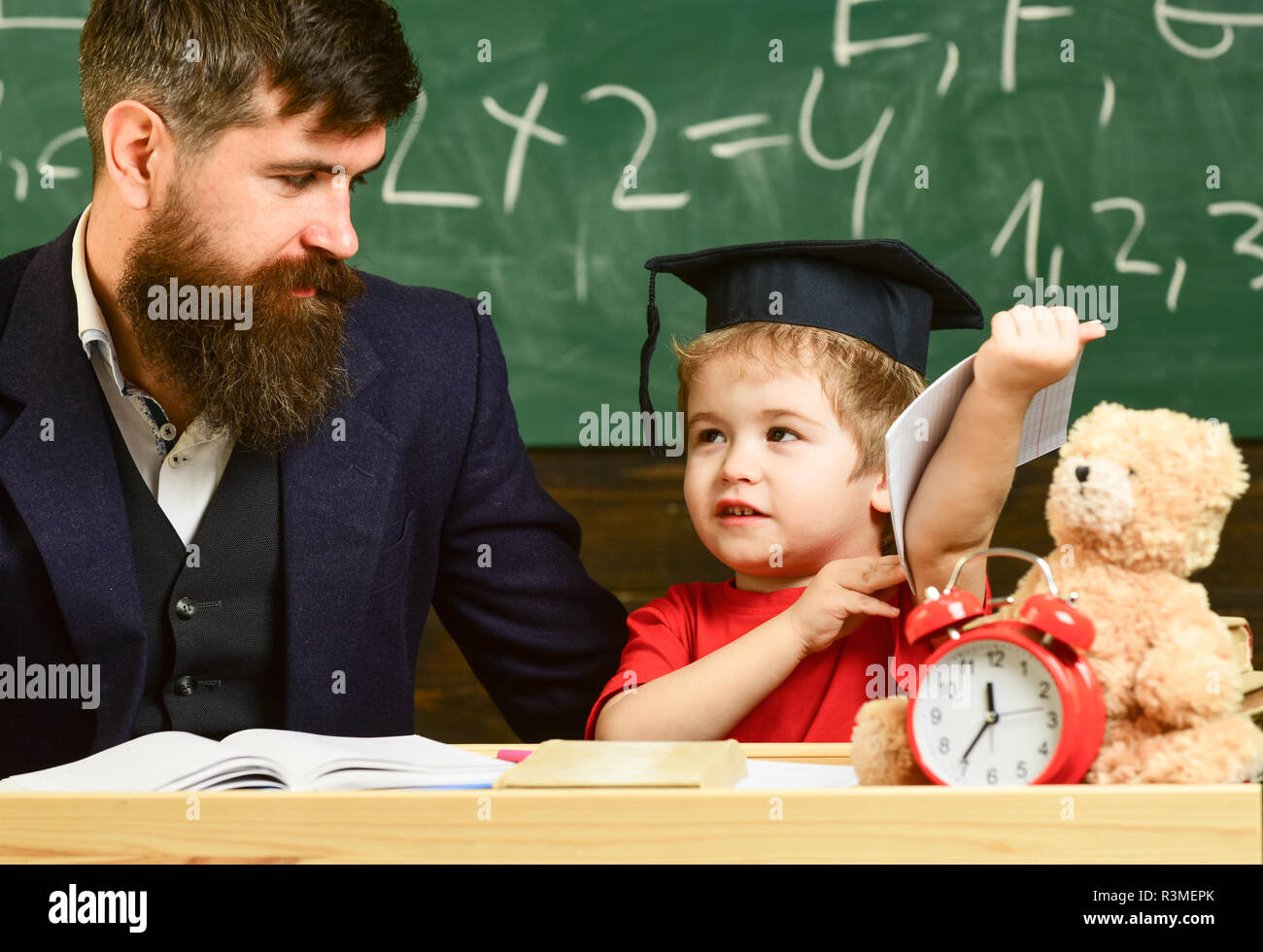 Father with beard, teacher teaches son, kid boy. Kid studies with ...