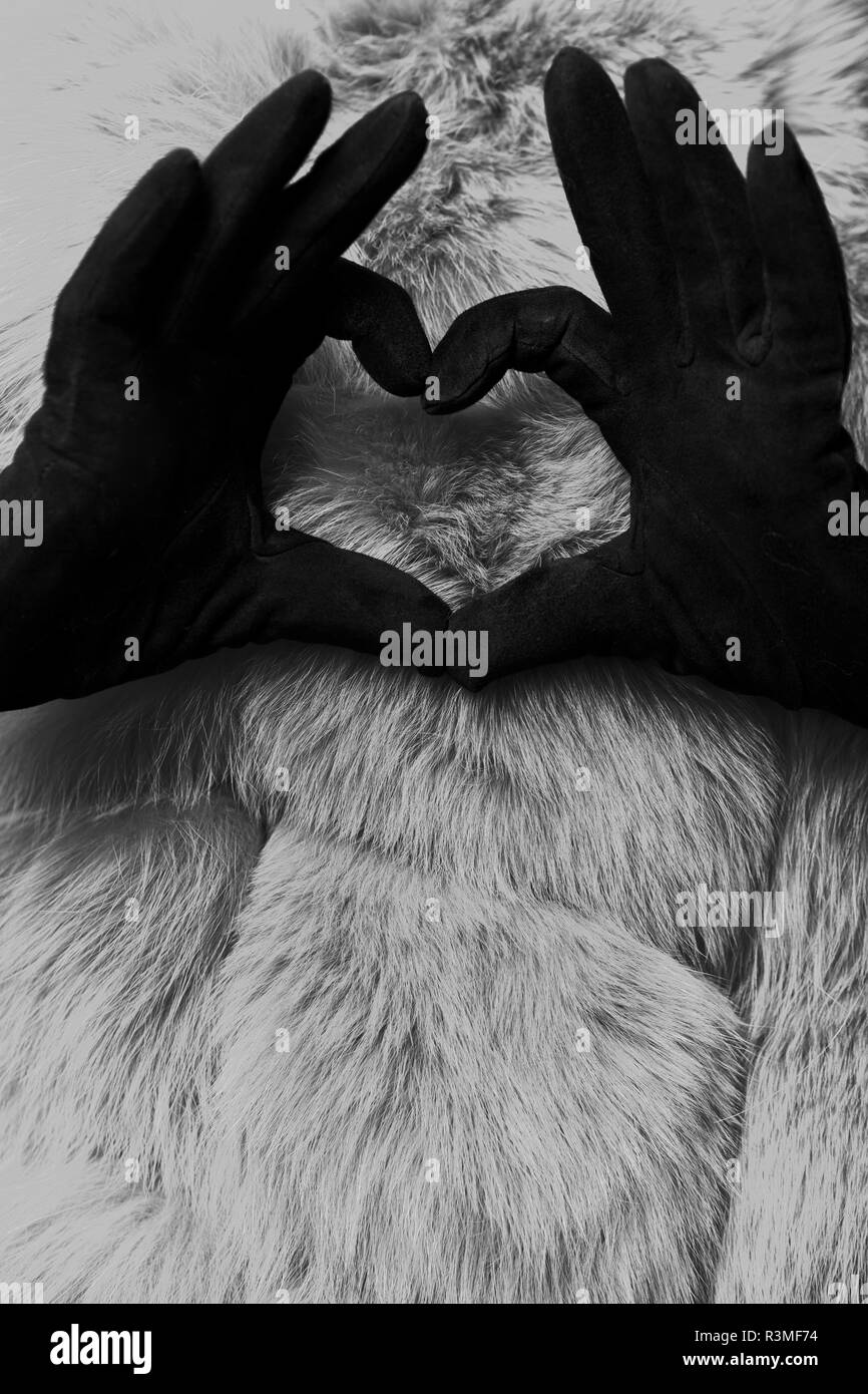 Artificial fur for texture or background. Female hands in black gloves ...