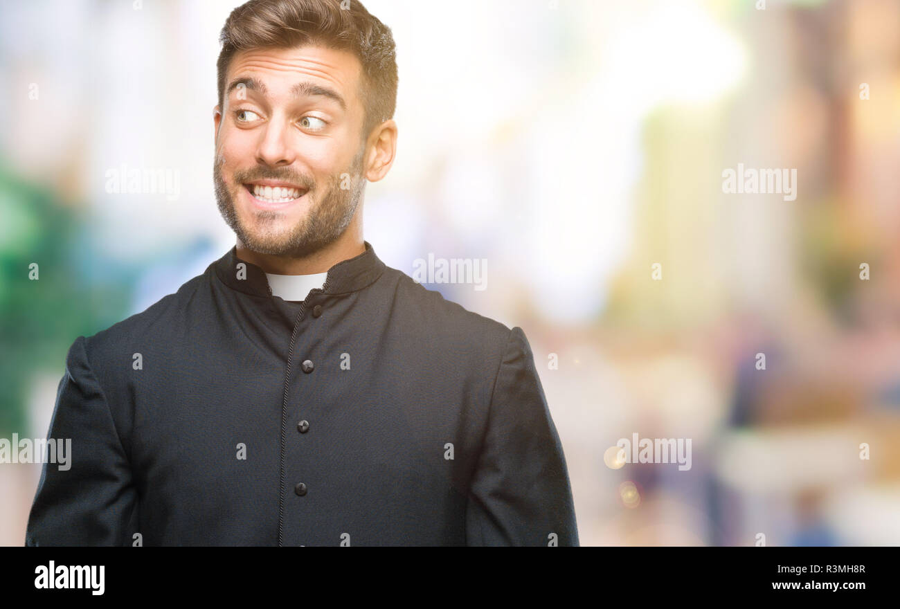 Young catholic christian priest man over isolated background smiling ...