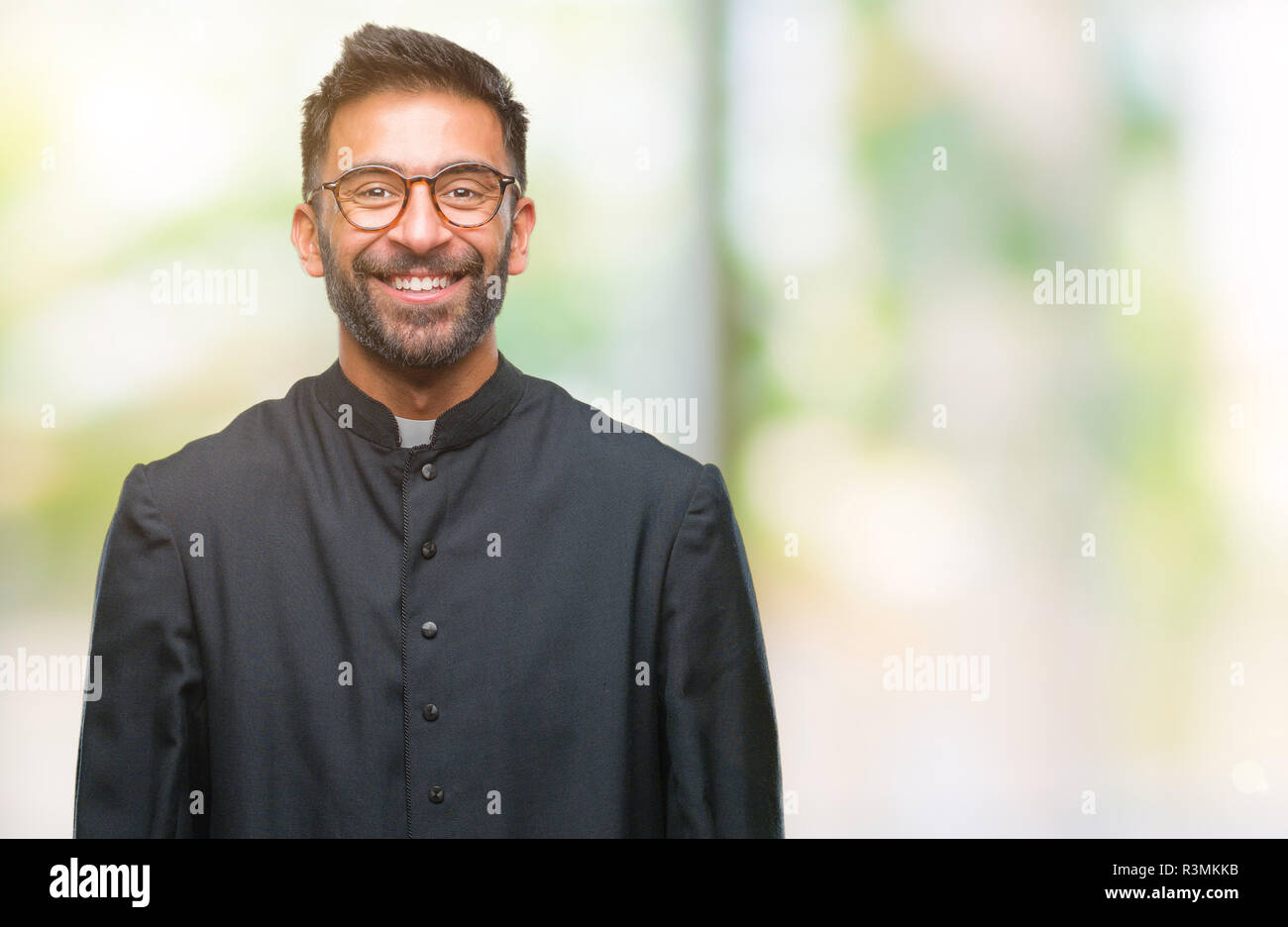 Adult hispanic catholic priest man over isolated background with a ...