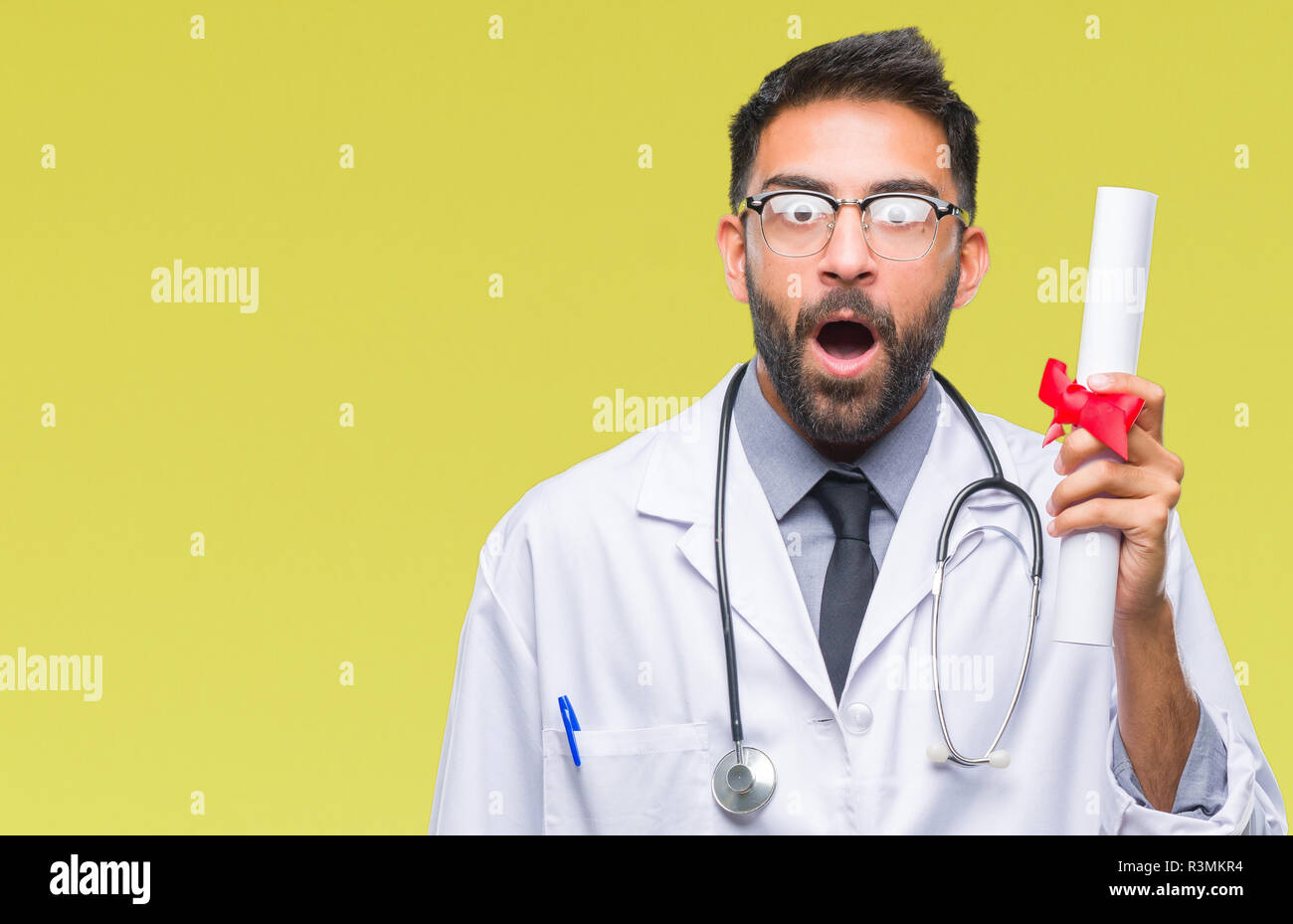 Adult hispanic doctor man holding degree over isolated background ...