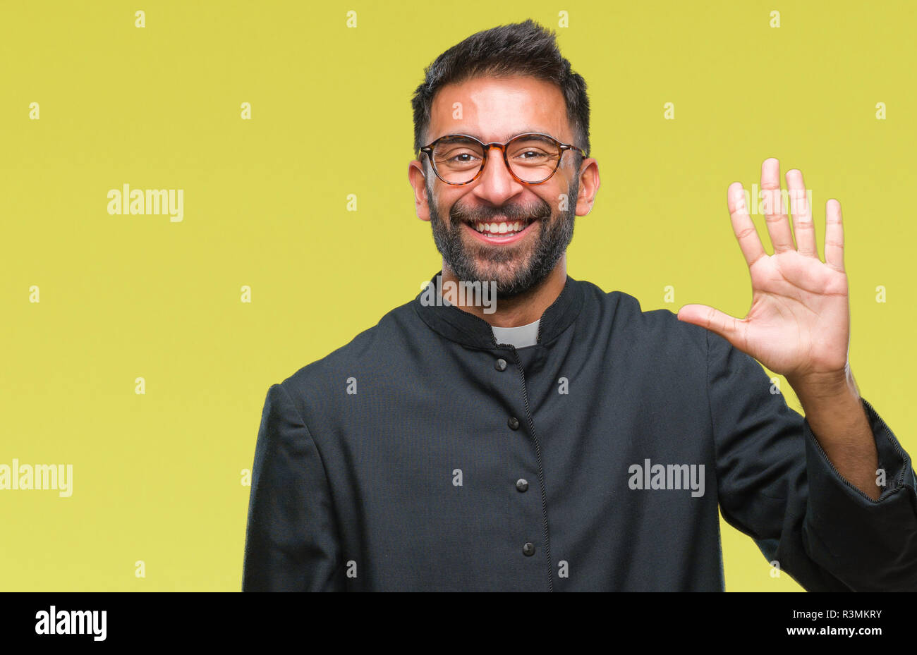 Adult hispanic catholic priest man over isolated background showing and ...