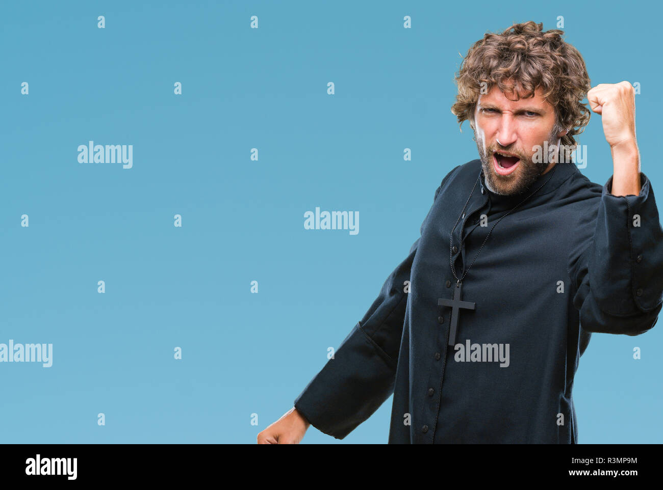 Handsome hispanic catholic priest man over isolated background angry ...