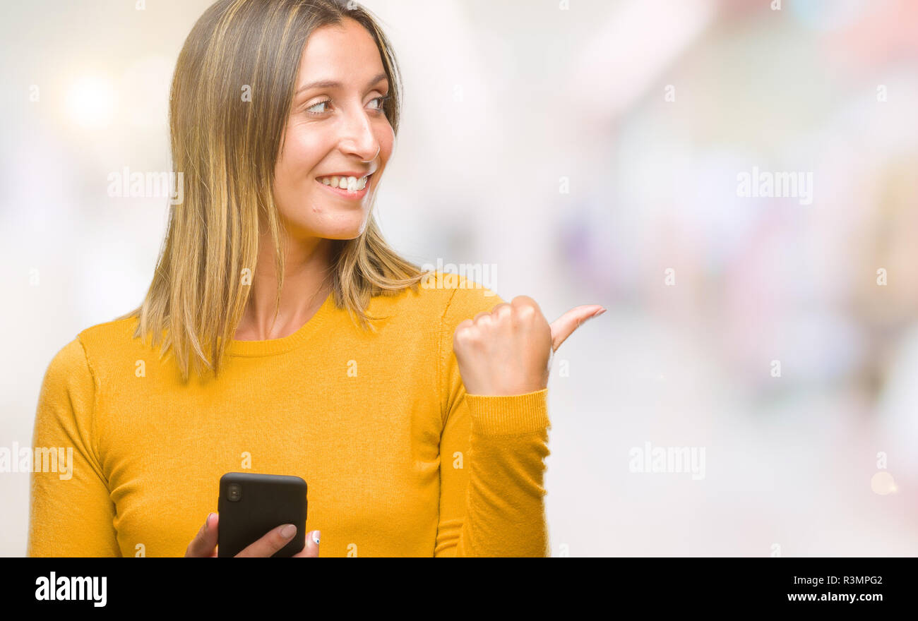 Young beautiful woman sending message using smartphone over isolated ...