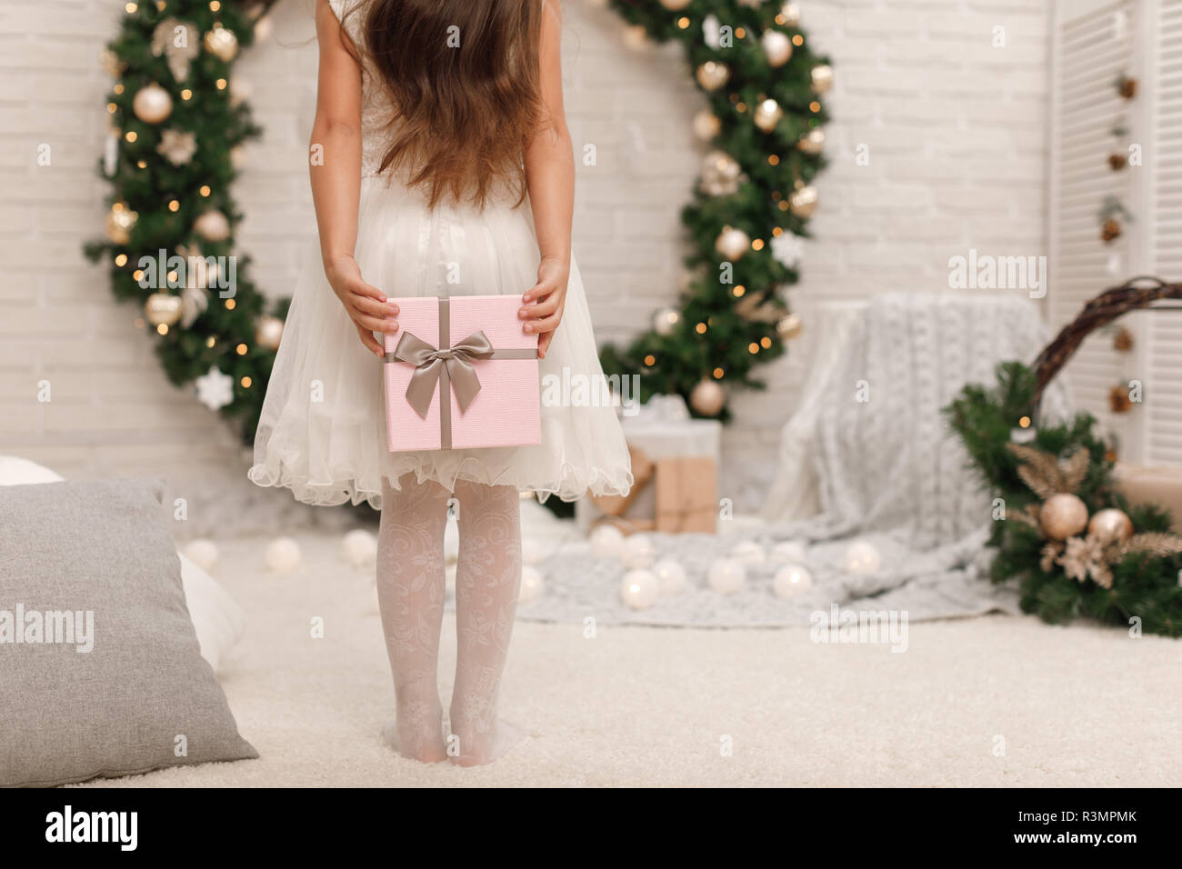 little child girl holding present box. Back view Stock Photo - Alamy
