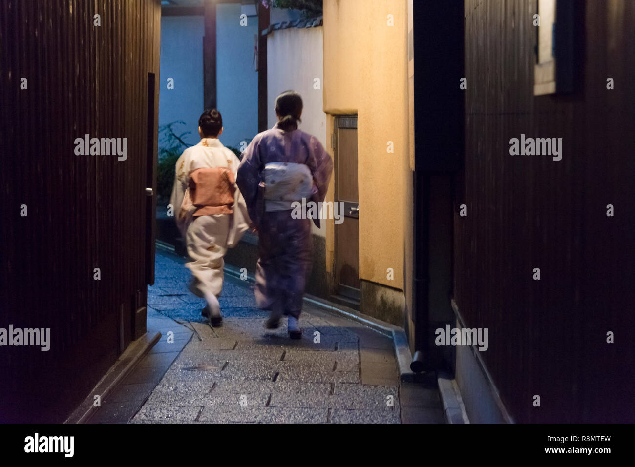 Women in traditional kimono walking on narrow lane on Hanami-Koji ...