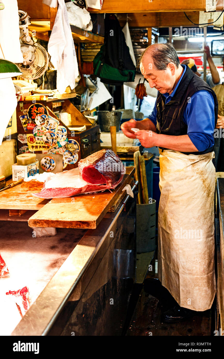 Tokyo, Japan. Fish monger prepares fish (tuna, toro) for sale, Tsukiji ...