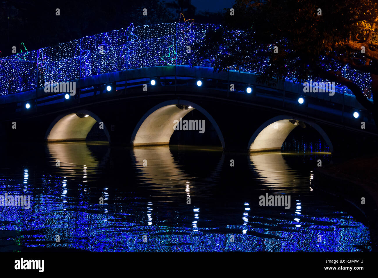 Night view of illuminated bridge with reflection in the water at ...
