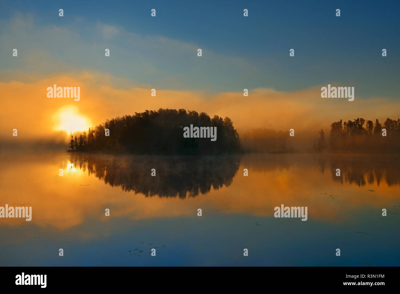 Canada, Ontario, Kenora. Reflections in Isabel Lake at sunrise Stock ...