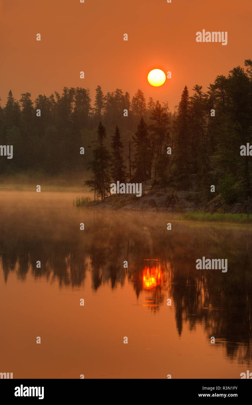 Canada, Ontario, Kenora. Reflections in Isabel Lake at sunrise Stock ...