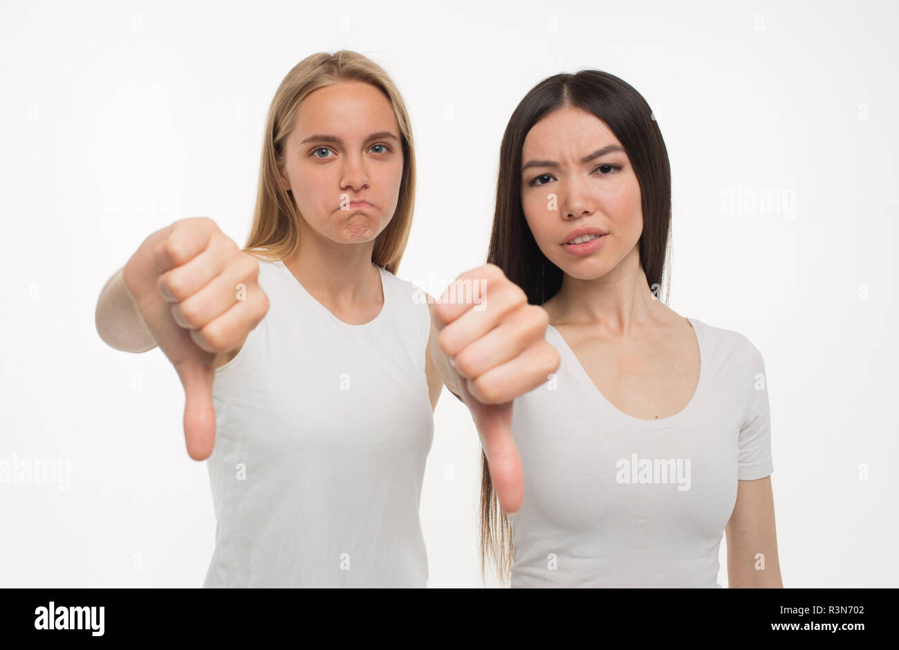 thumb down. Two women on a white background isolated Stock Photo - Alamy