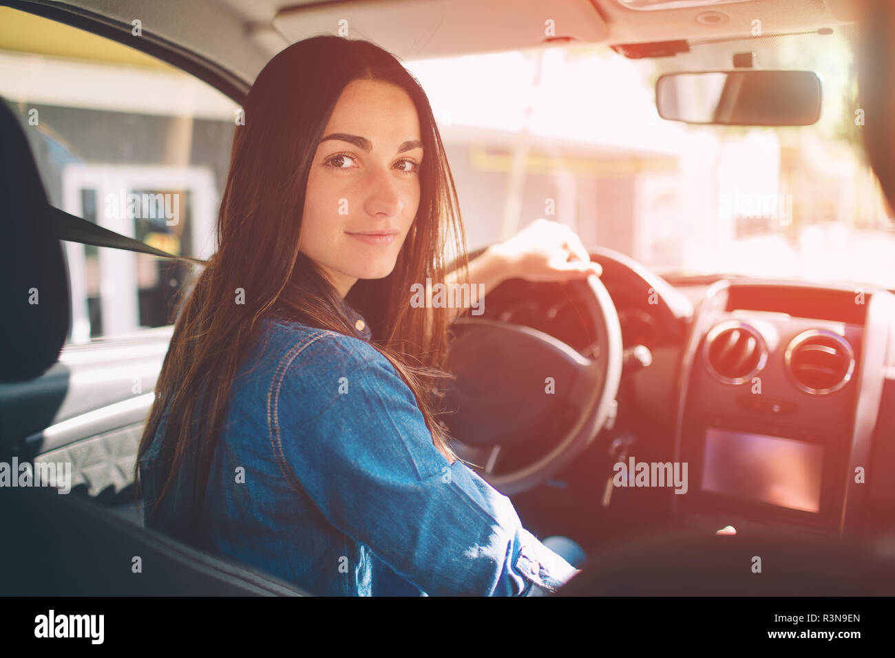 The young woman driving the car smiling Stock Photo - Alamy