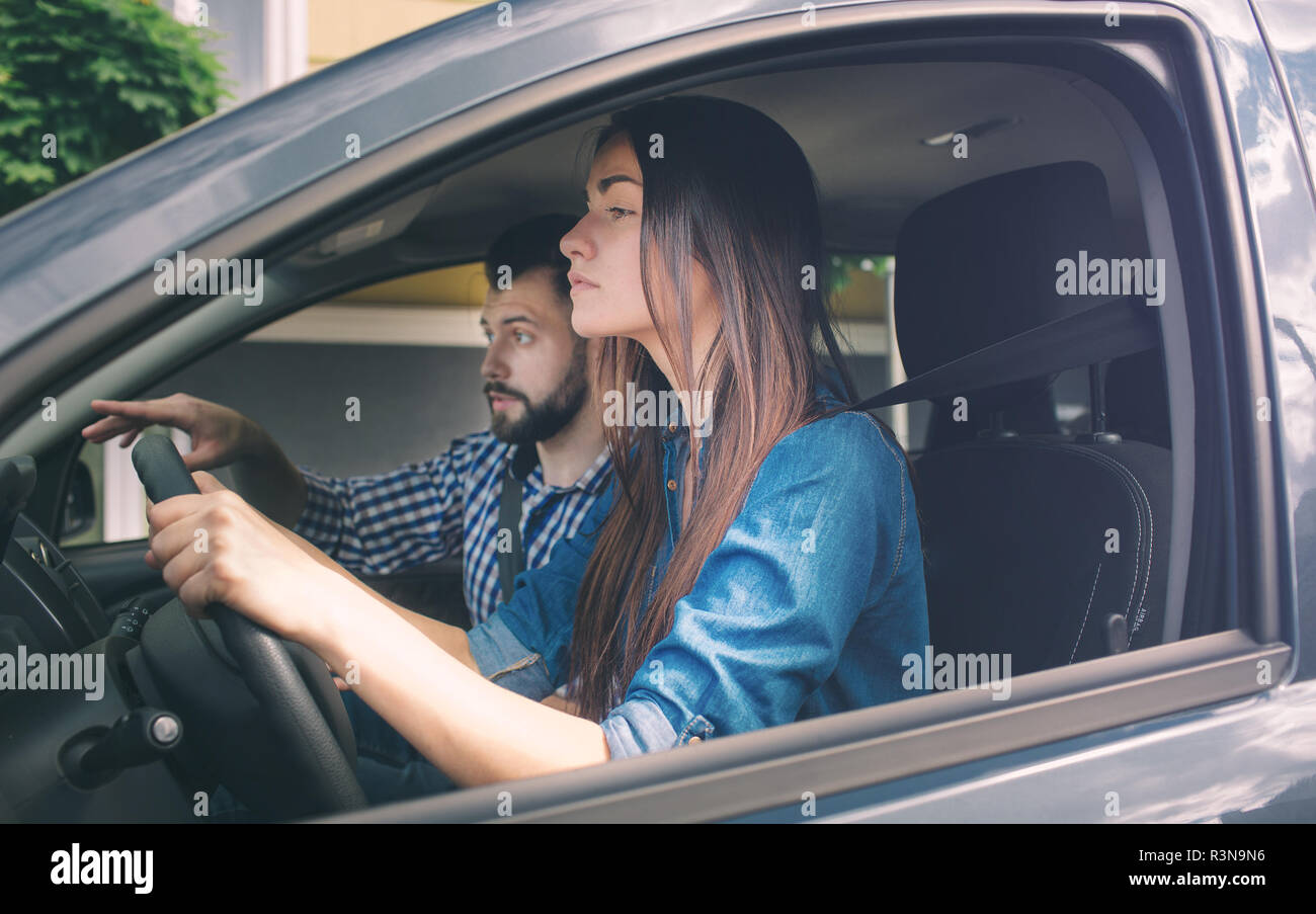 Driving test. Young serious woman driving car feeling inexperienced ...