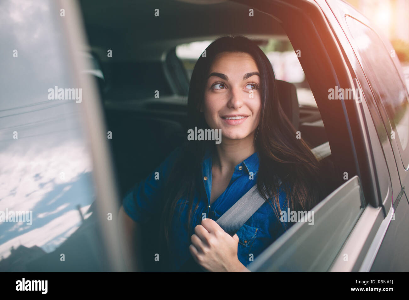 Beautiful woman smiling while sitting on back seat in the car Stock ...