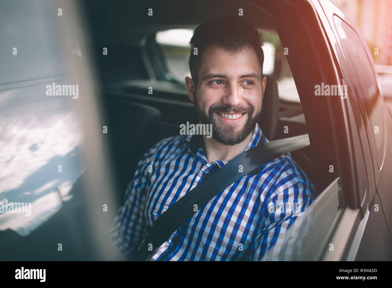 Beautiful man smiling while sitting on back seat in the car Stock Photo ...