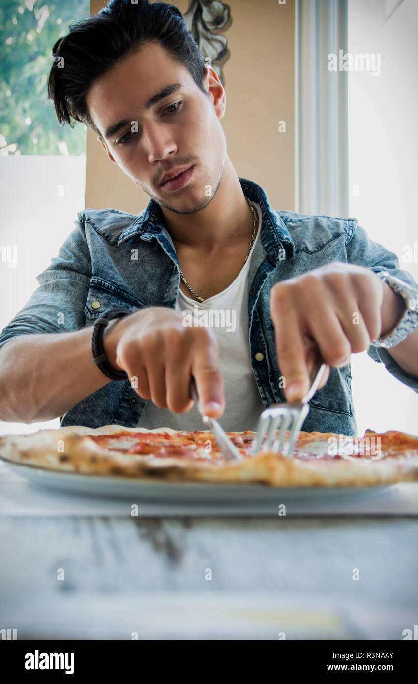 Handsome man eating fork knife hi-res stock photography and images - Alamy