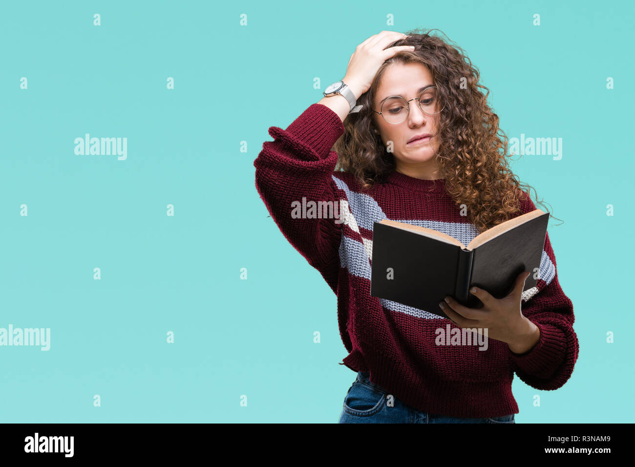 Young brunette girl reading a book wearing glasses over isolated ...