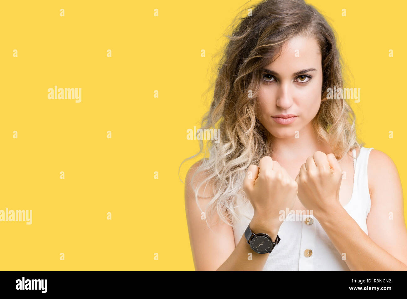 Beautiful young blonde woman over isolated background Ready to fight ...