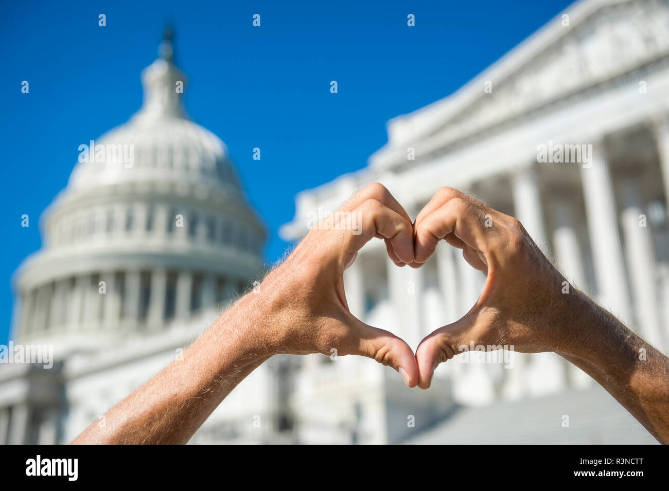 Happy fingers forming a hand heart on a bright sunny view of the ...
