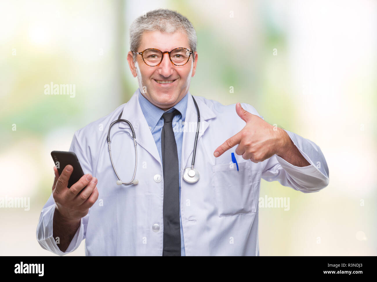 Handsome senior doctor man texting sending message using smarpthone ...