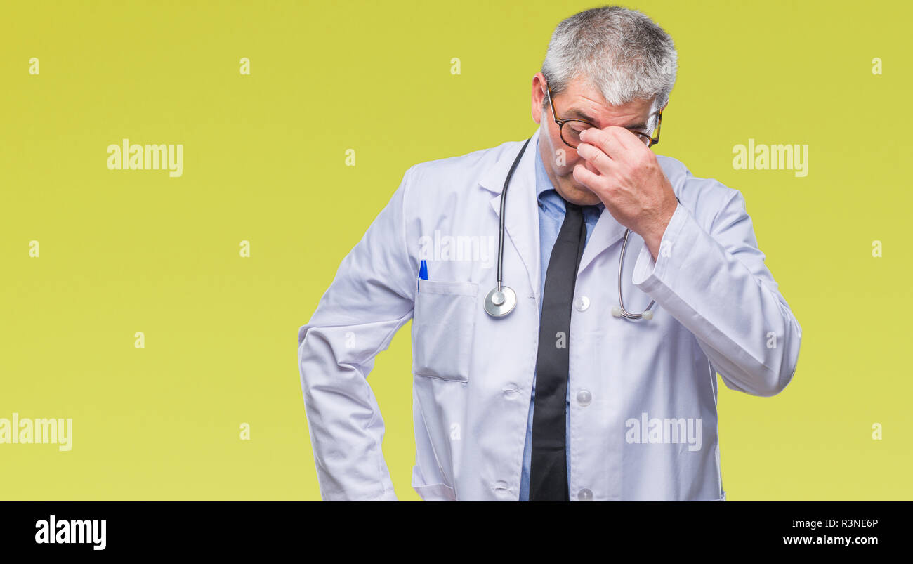 Handsome senior doctor man over isolated background tired rubbing nose ...