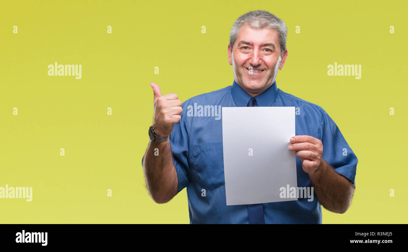 Handsome senior man holding blank sheet paper over isolated background ...