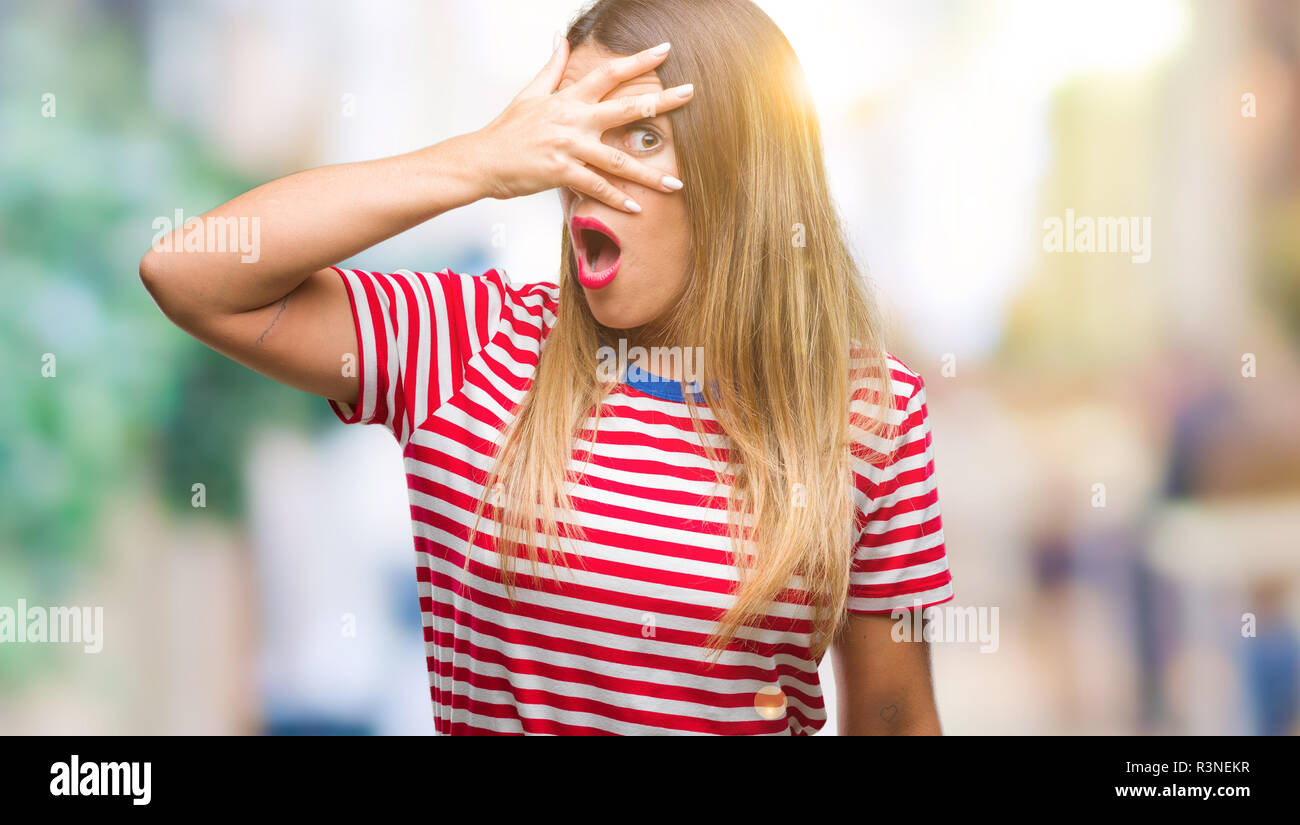 Young beautiful woman casual look over isolated background peeking in ...
