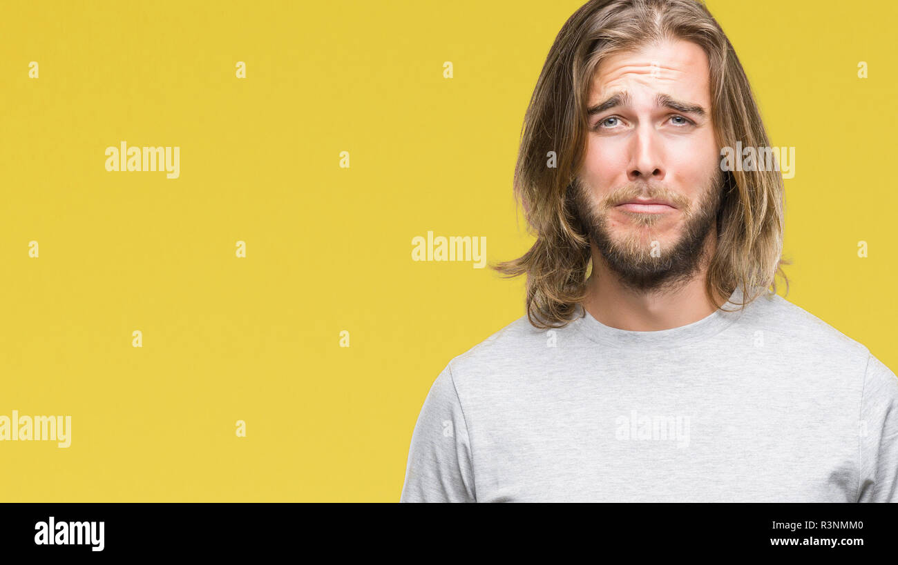 Young handsome man with long hair over isolated background depressed ...