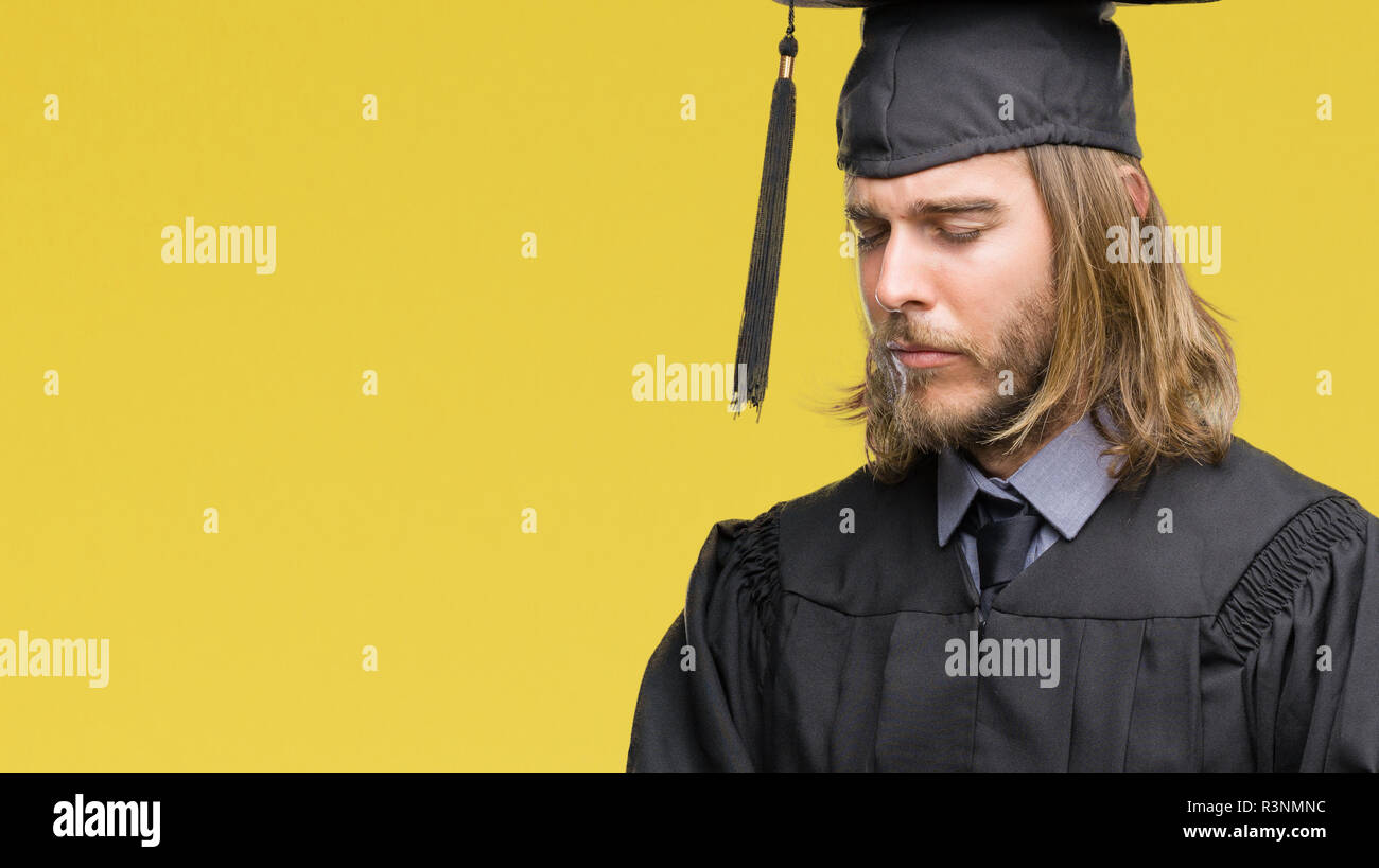 Young handsome graduated man with long hair over isolated background ...