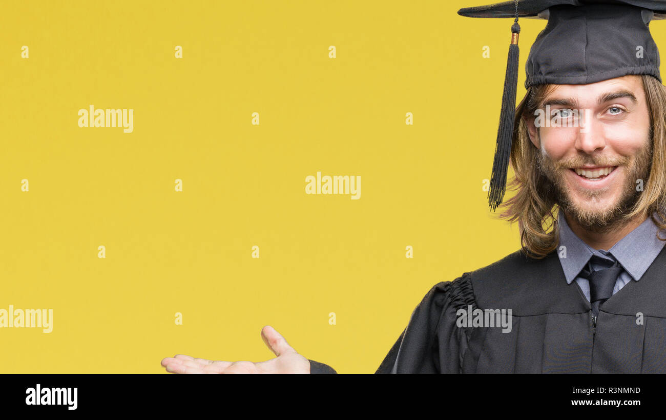 Young handsome graduated man with long hair over isolated background ...