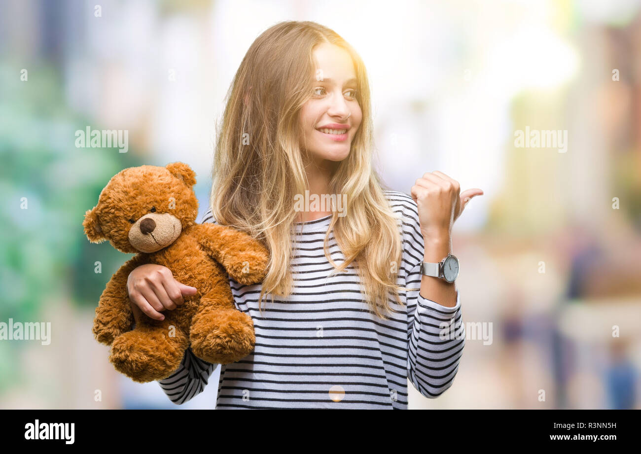 Young beautiful blonde woman holding teddy bear plush over isolated ...