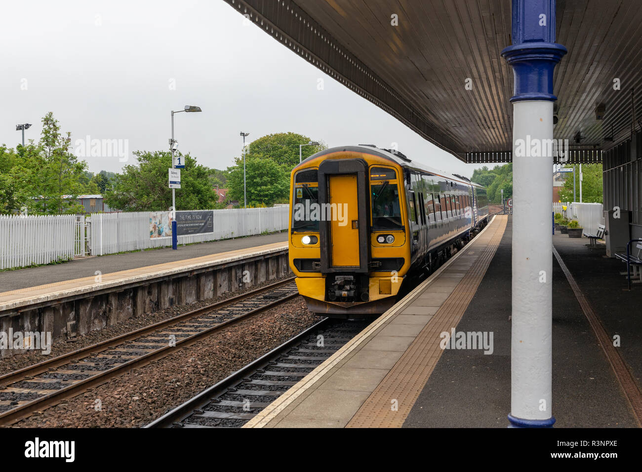 Rural railway station with platform and train waiting for departure ...