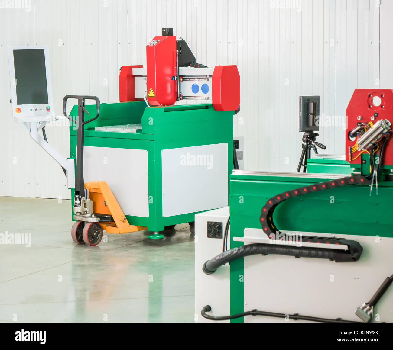 Industrial laser cutter with sparks on hydraulic trolley near other ...