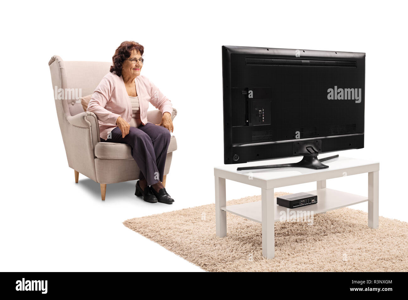 Senior lady sitting in an armchair and watching television isolated on ...