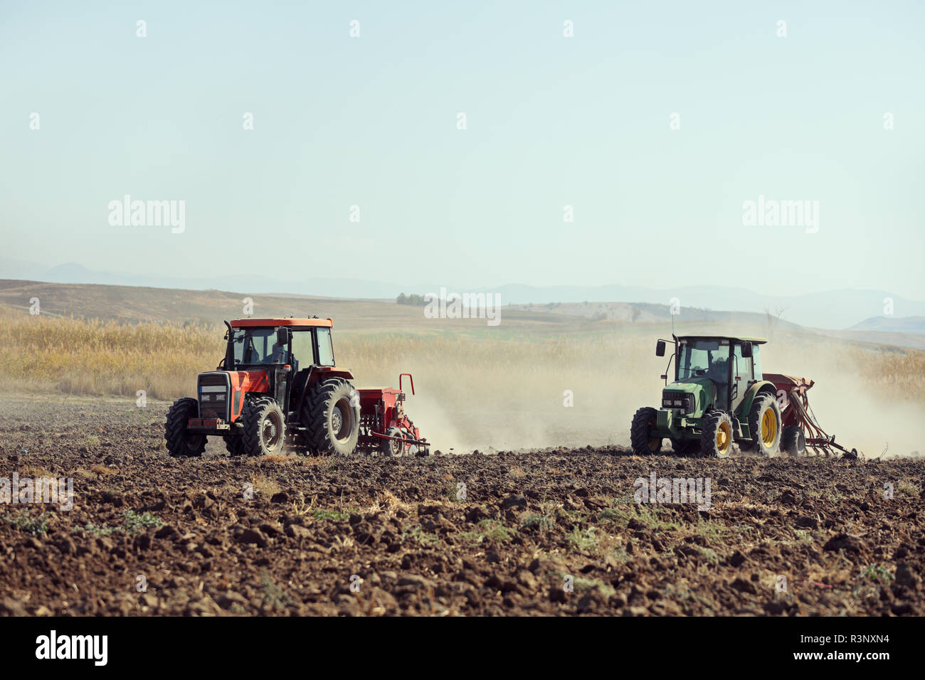 Two tractors ploughing a field Stock Photo - Alamy