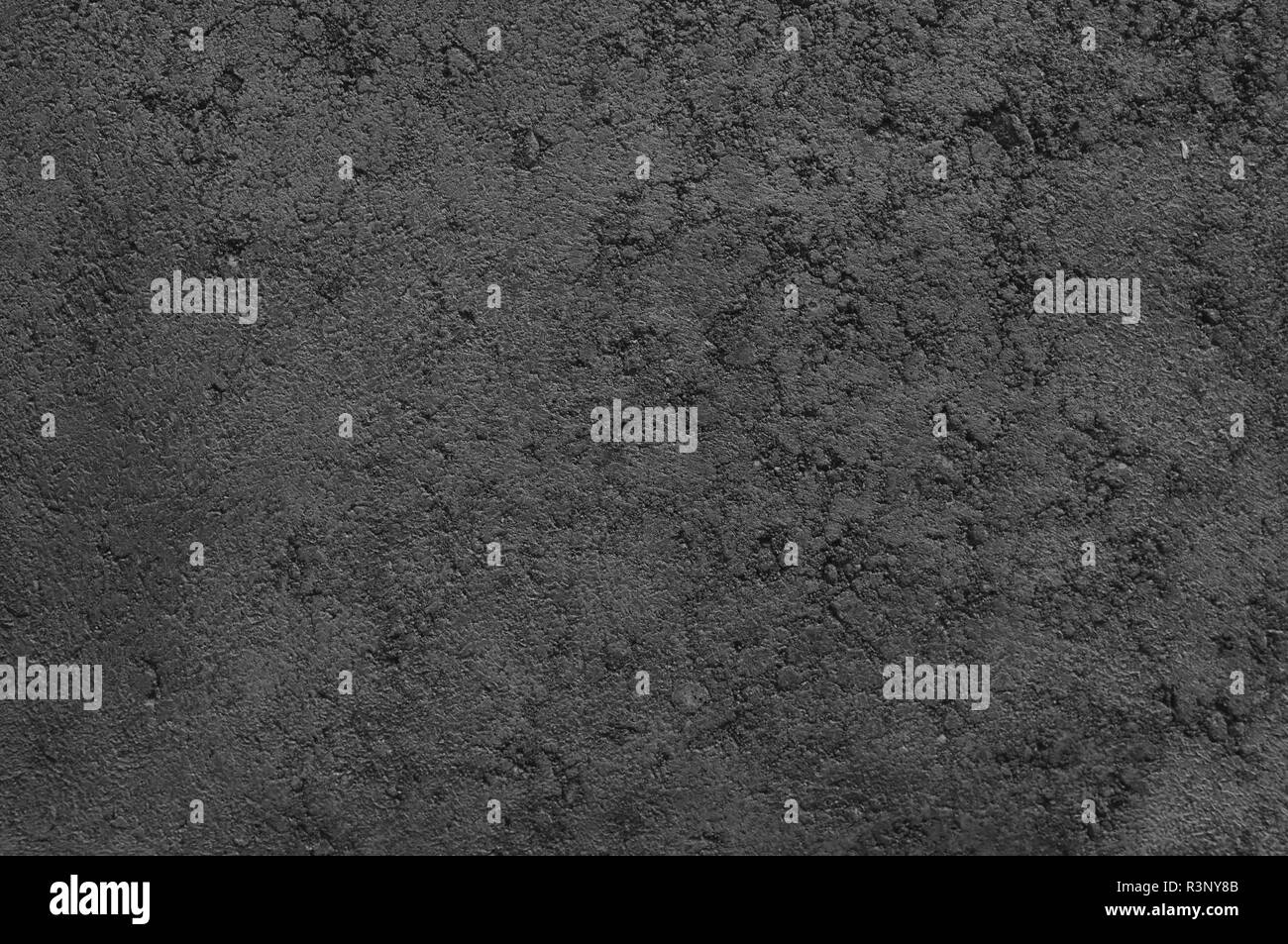An area of coarse concrete in gray with a lot of texture fills the ...