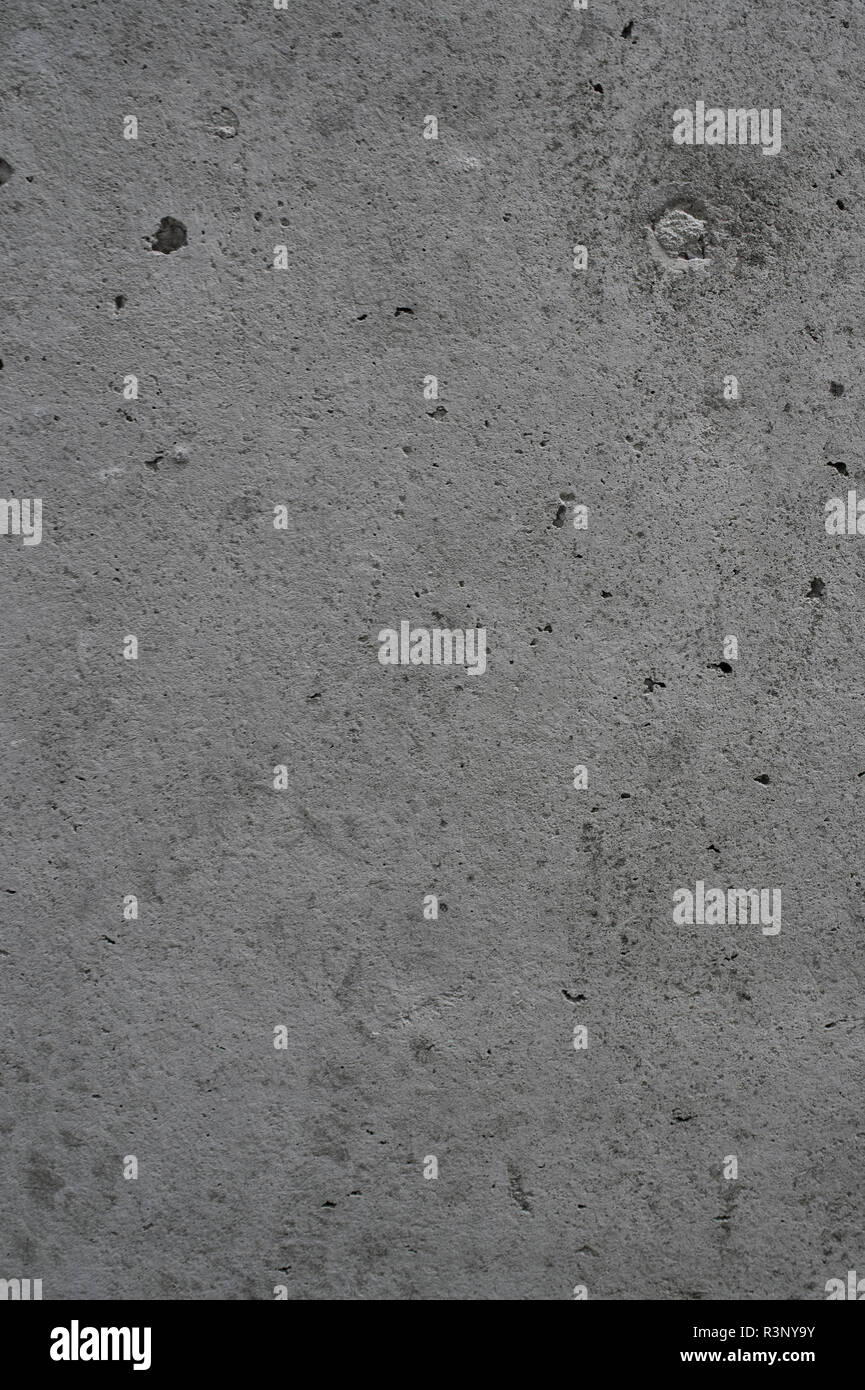 An area of coarse concrete in gray with a lot of texture fills the ...
