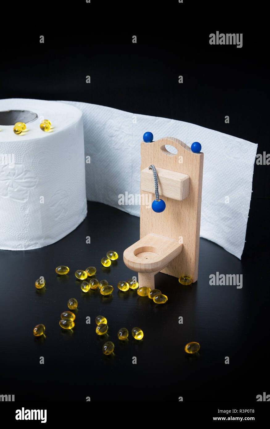 Wooden toy toilet, capsules and paper on black Stock Photo - Alamy