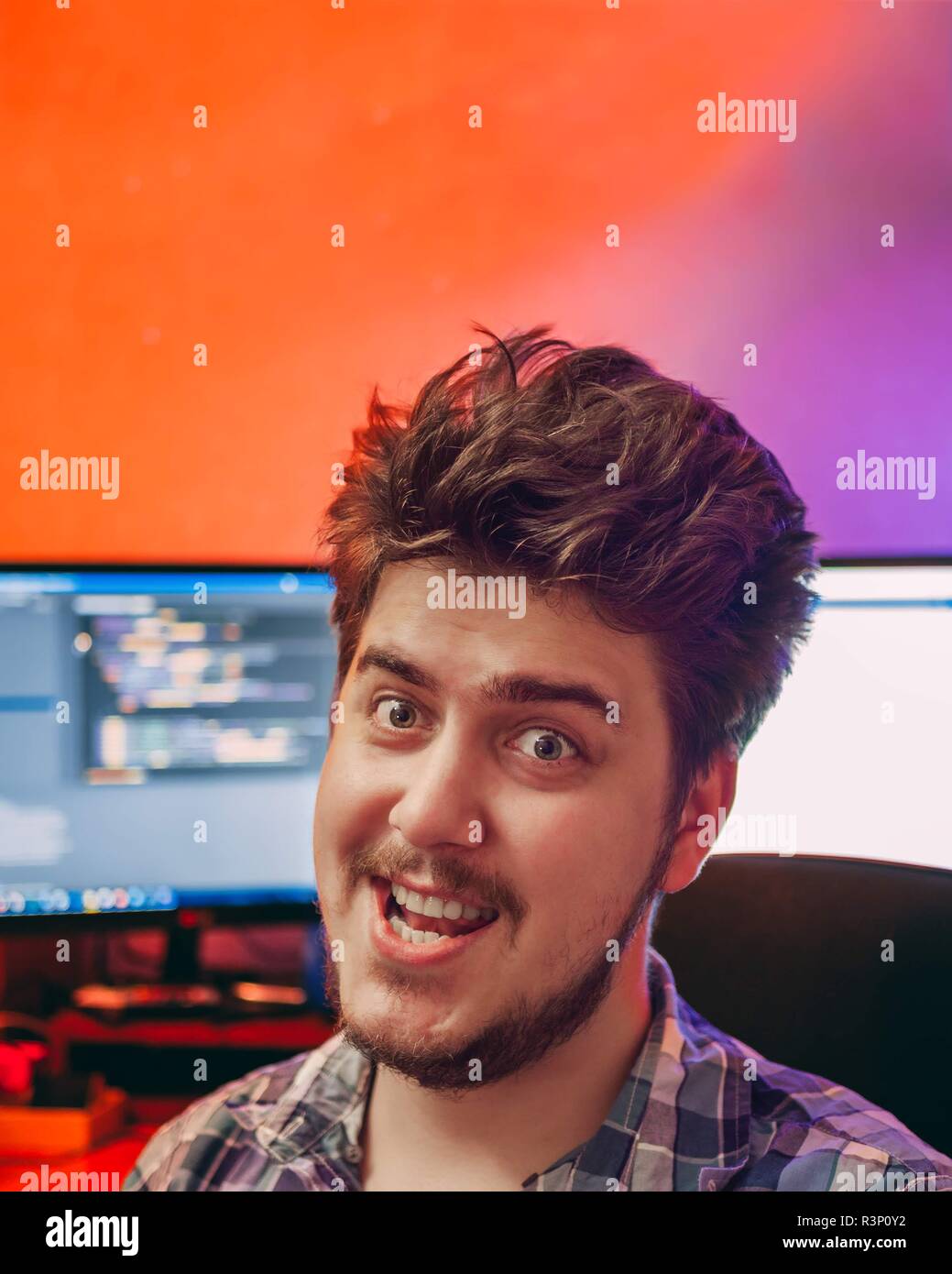 Portrait of man makes an appearance with computer and colored light on ...