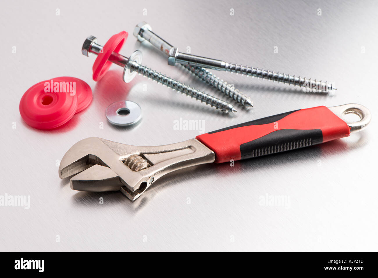 Spanner tool and screws on metal finish background Stock Photo - Alamy