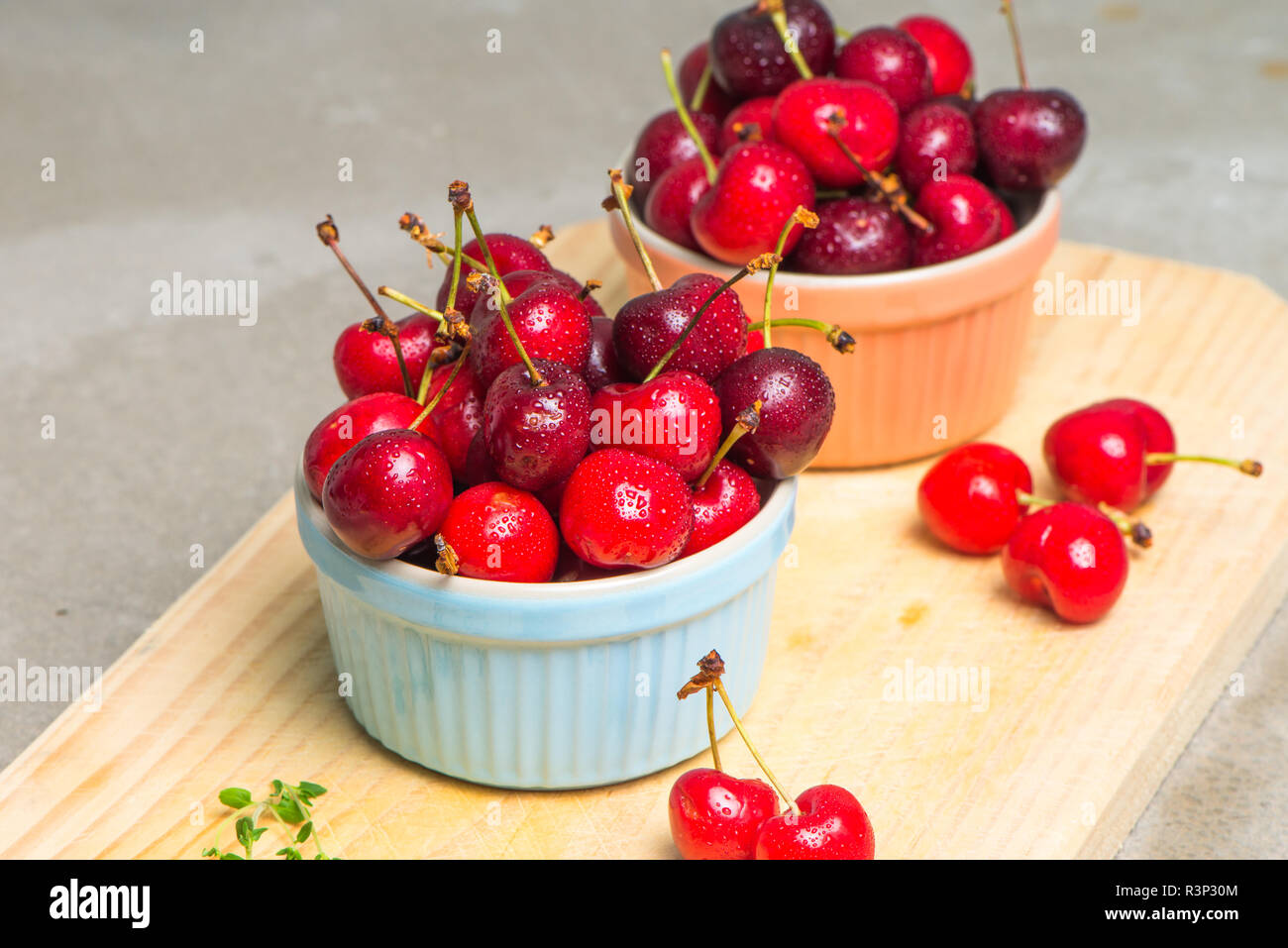 Red ripe cherries in ceramic bowls on kitchen countertop Stock Photo ...