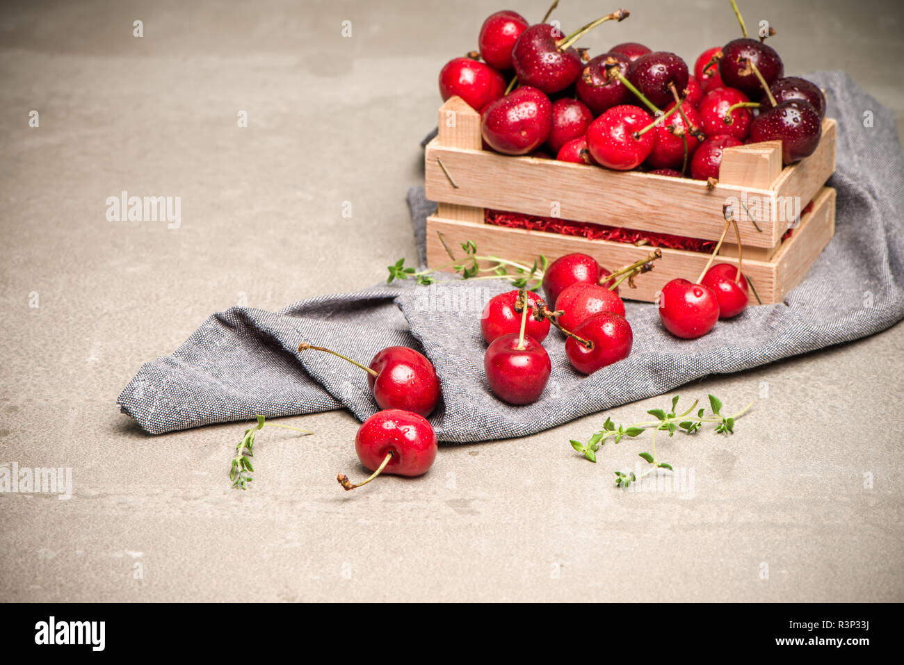 Red ripe cherries in small wooden box on kitchen countertop Stock Photo ...
