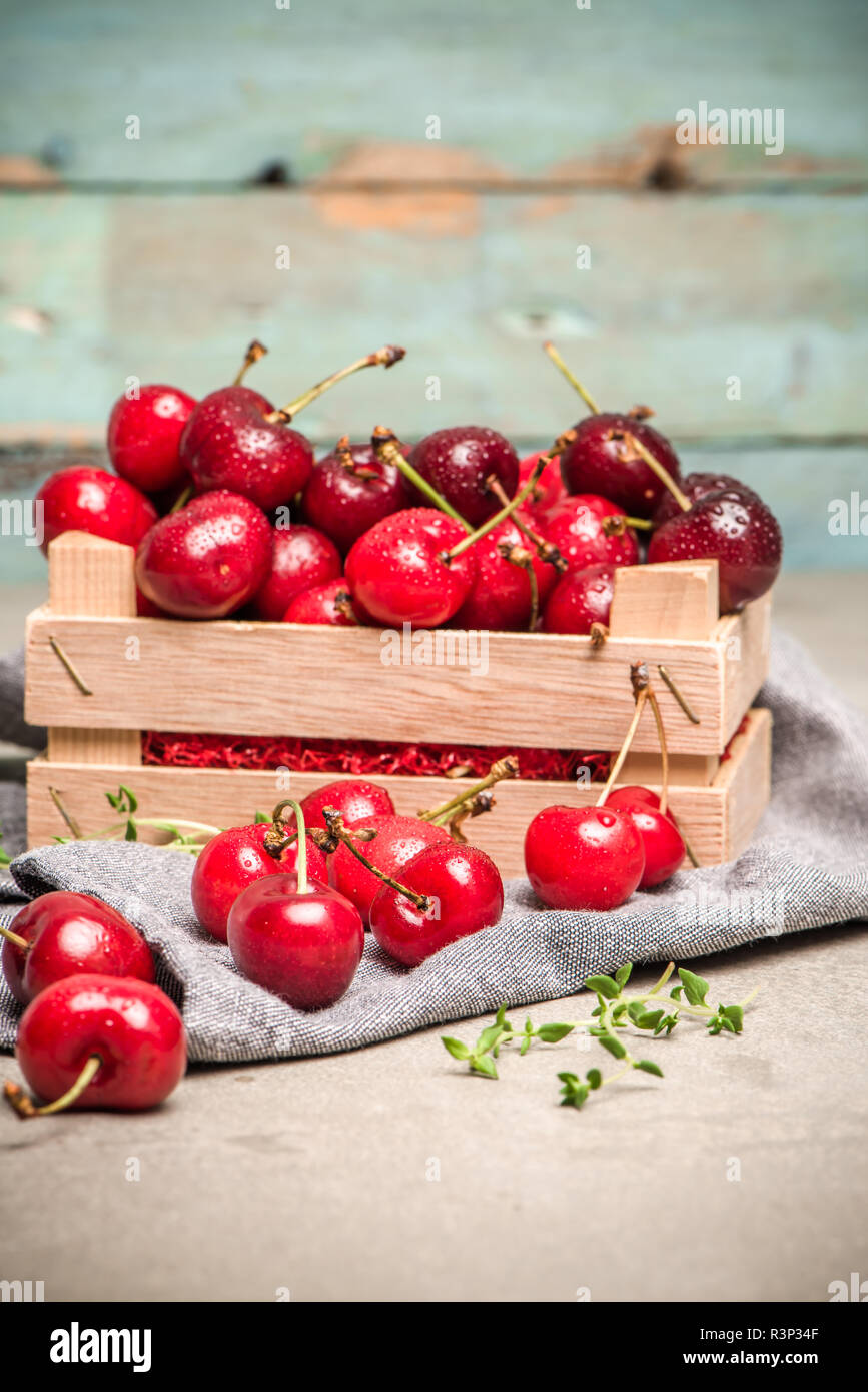 Red ripe cherries in small wooden box on kitchen countertop Stock Photo ...
