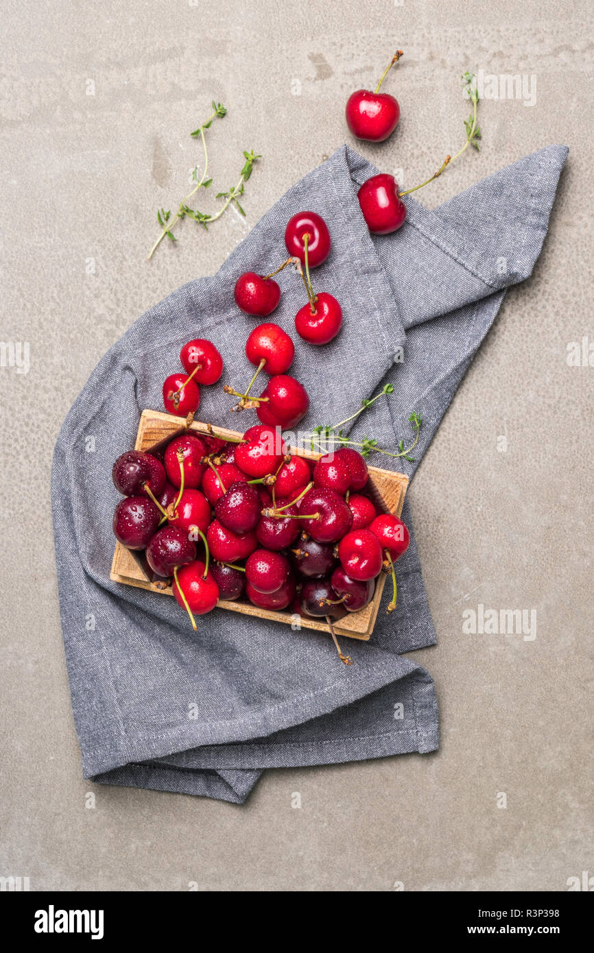 Red ripe cherries in small wooden box on kitchen countertop Stock Photo ...