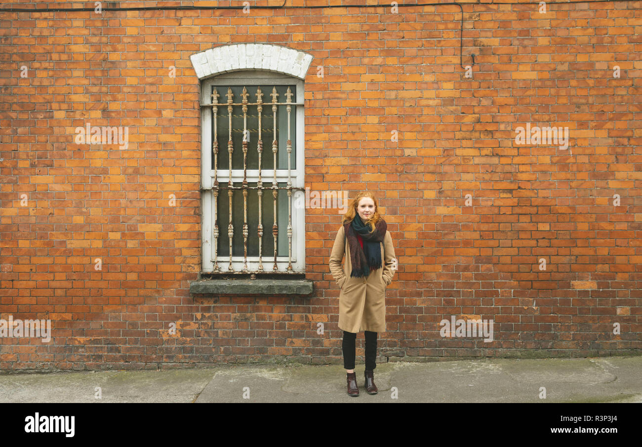Woman standing against brick wall hi-res stock photography and images ...
