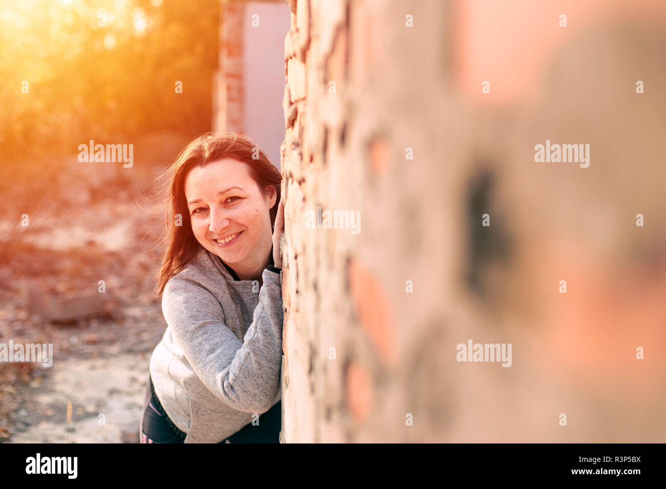 Hiding behind wall hi-res stock photography and images - Alamy