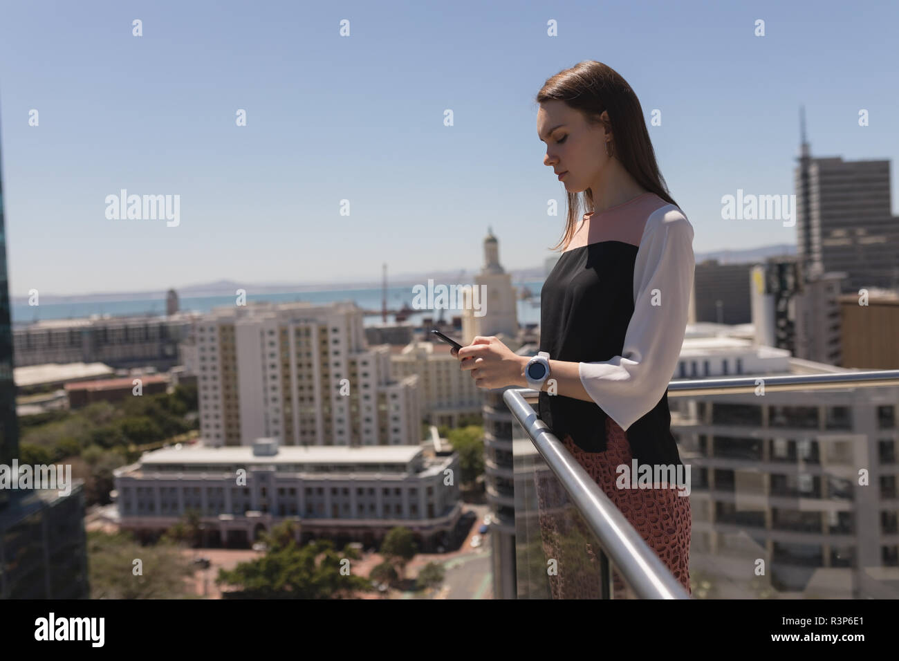 Female executive using mobile phone at terrace Stock Photo - Alamy