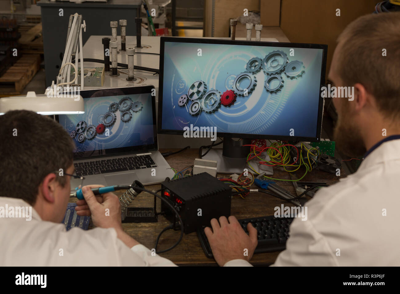 Robotics engineers working at desk in warehouse Stock Photo - Alamy